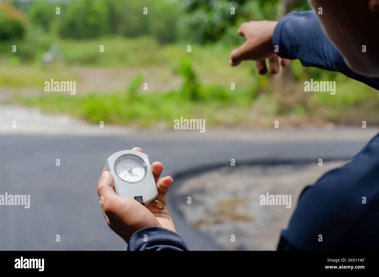 A male showing direction using a mini compass Stock Photo - Alamy