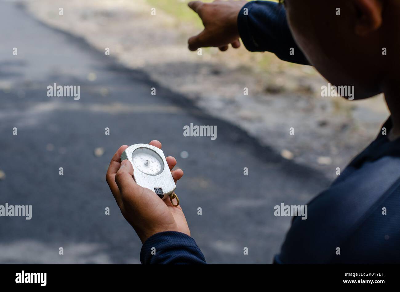A male showing direction using a mini compass Stock Photo - Alamy