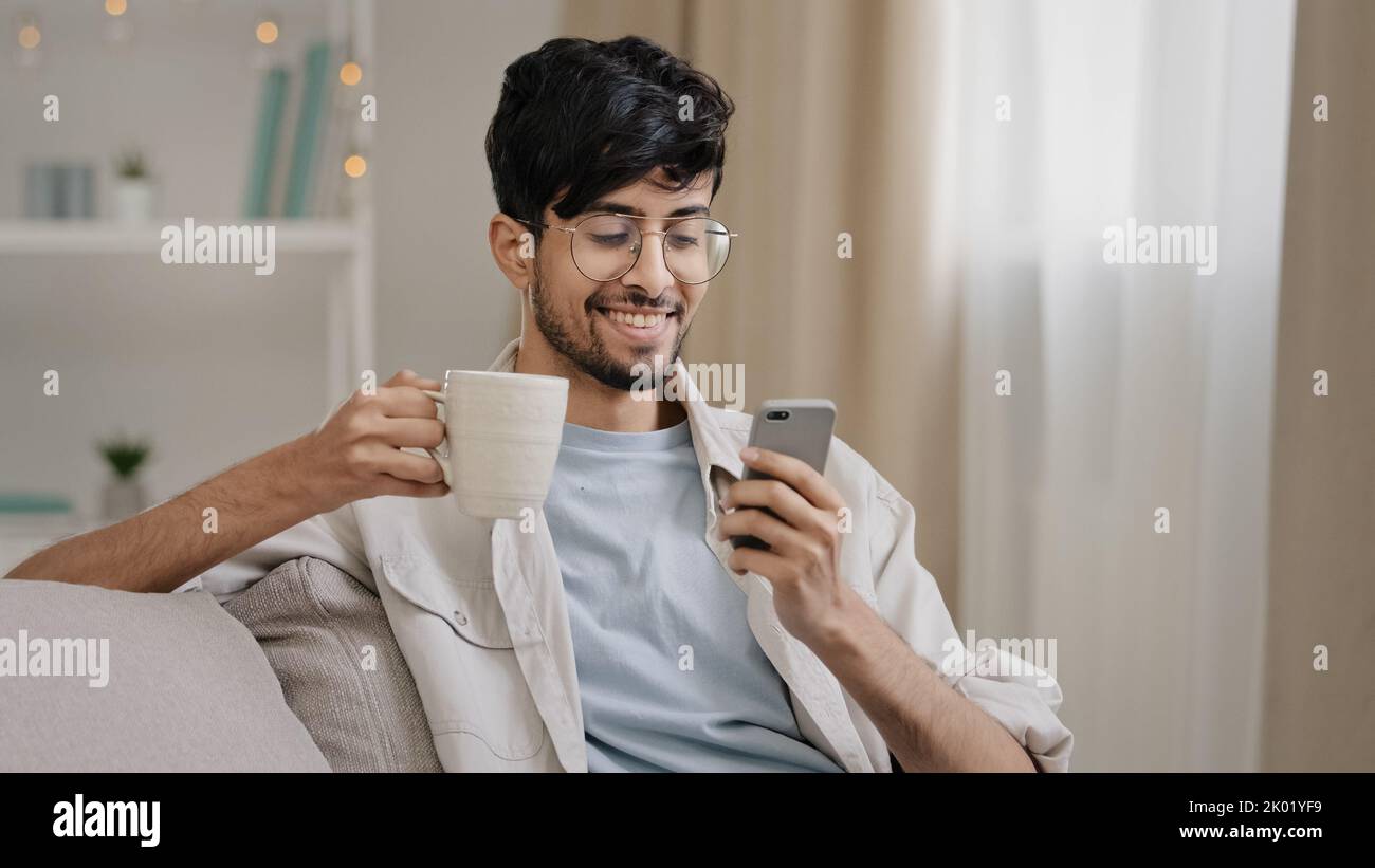 Millennial arabic guy indian handsome 30s man sitting at home on couch ...