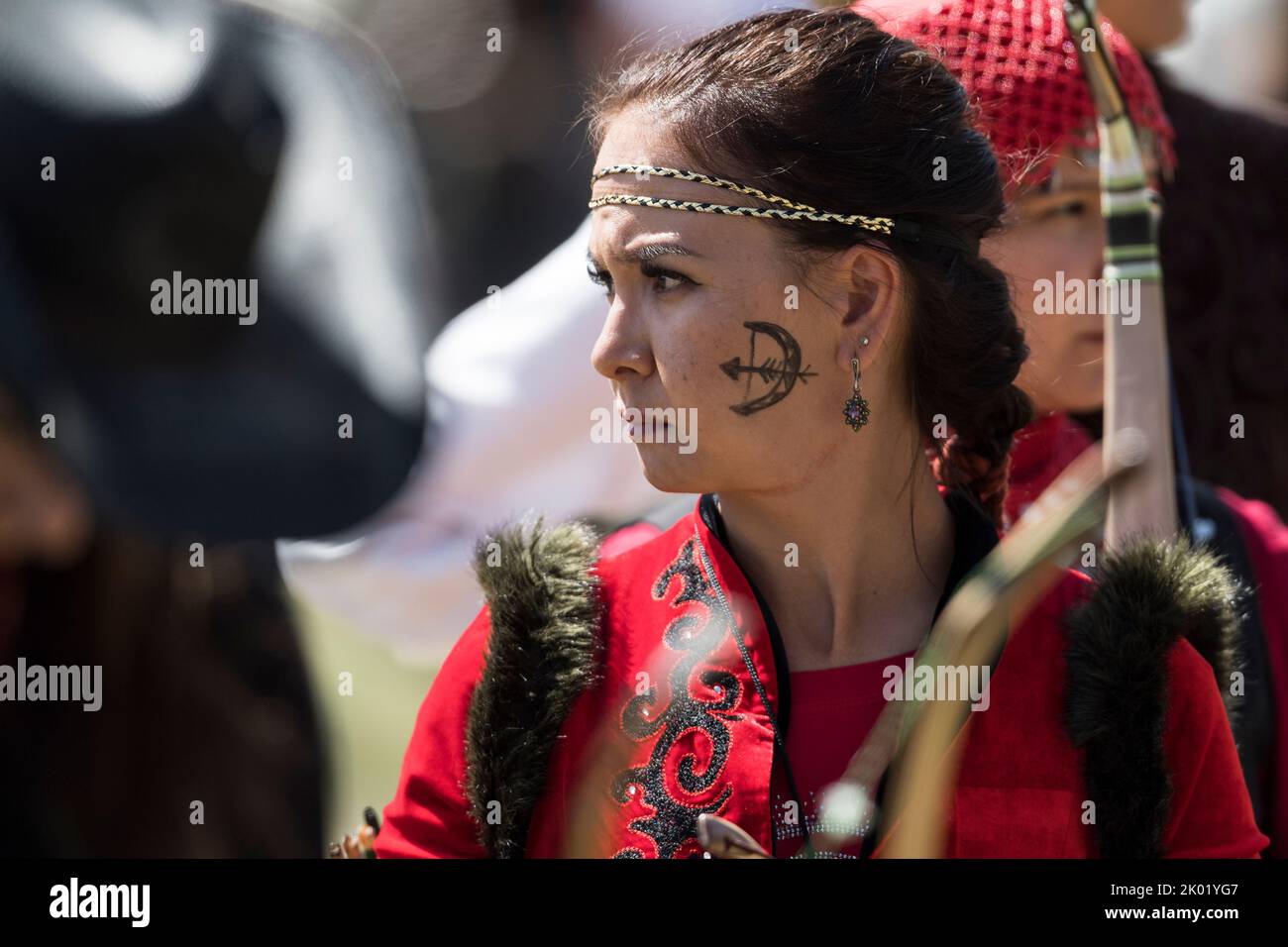 Portrait of female archer in ethnic costume during the archery ...