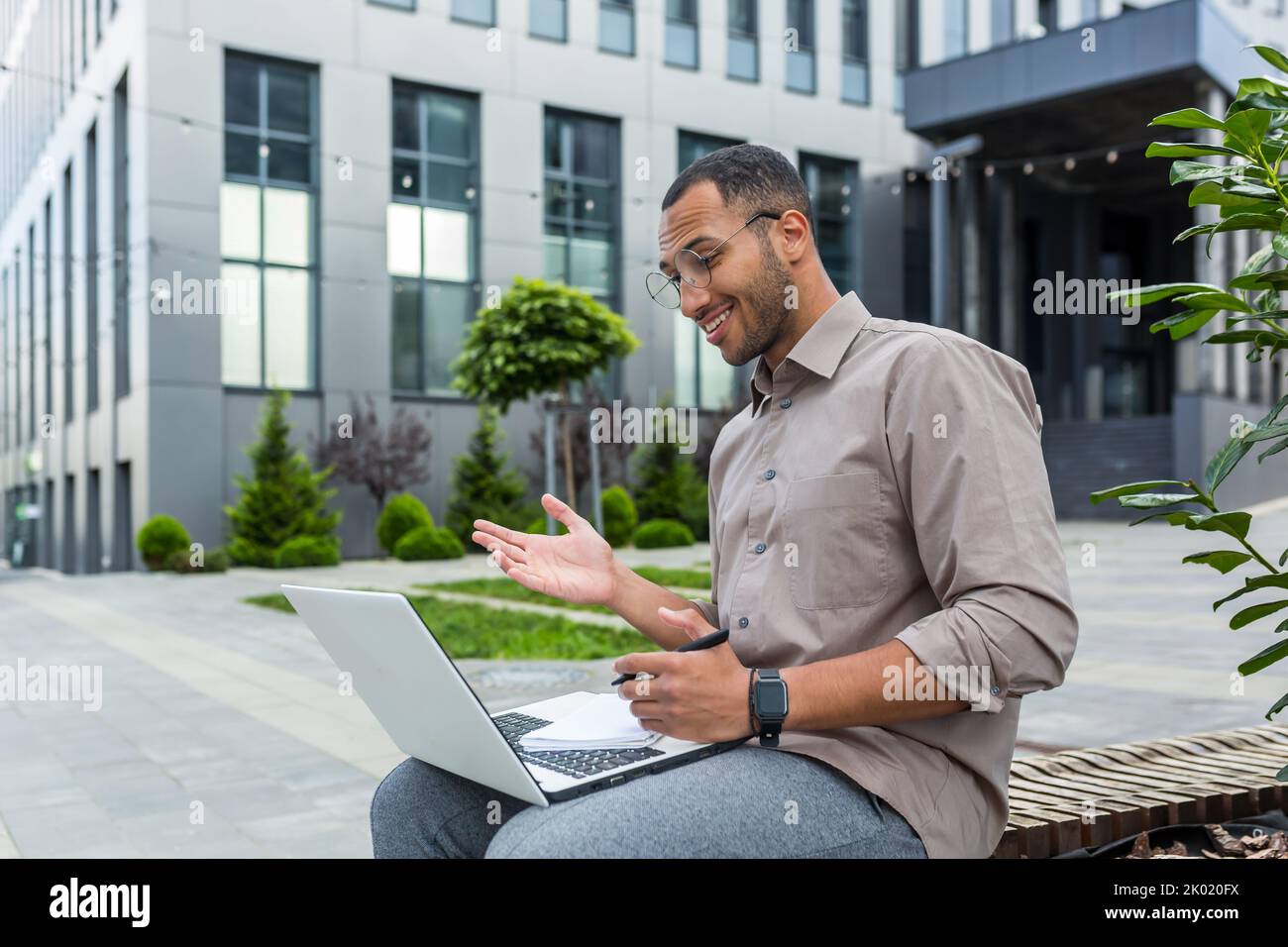 Young african american student studying sitting on bench outside ...