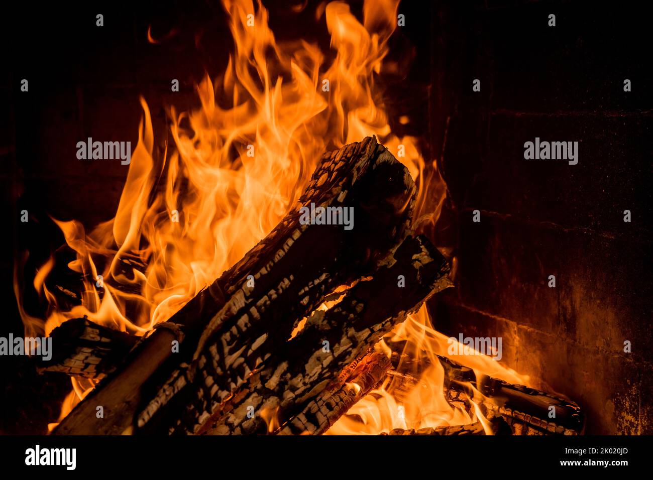 The fire with flames is burning in the wood-fired firewood pizza oven ...