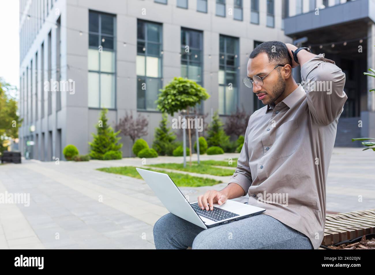 Serious and pensive man sitting on bench unhappy with work result ...