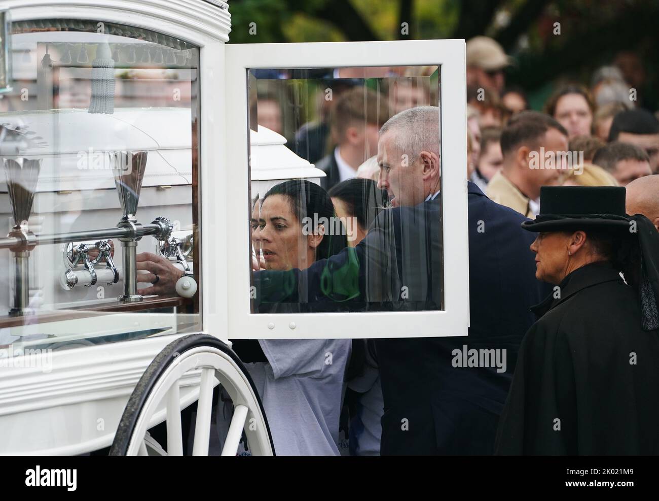 A coffin is placed in a horse drawn hearse following the funeral ...
