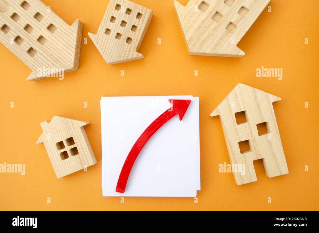 Wooden houses and arrow up. Real estate value increase. Rising prices ...