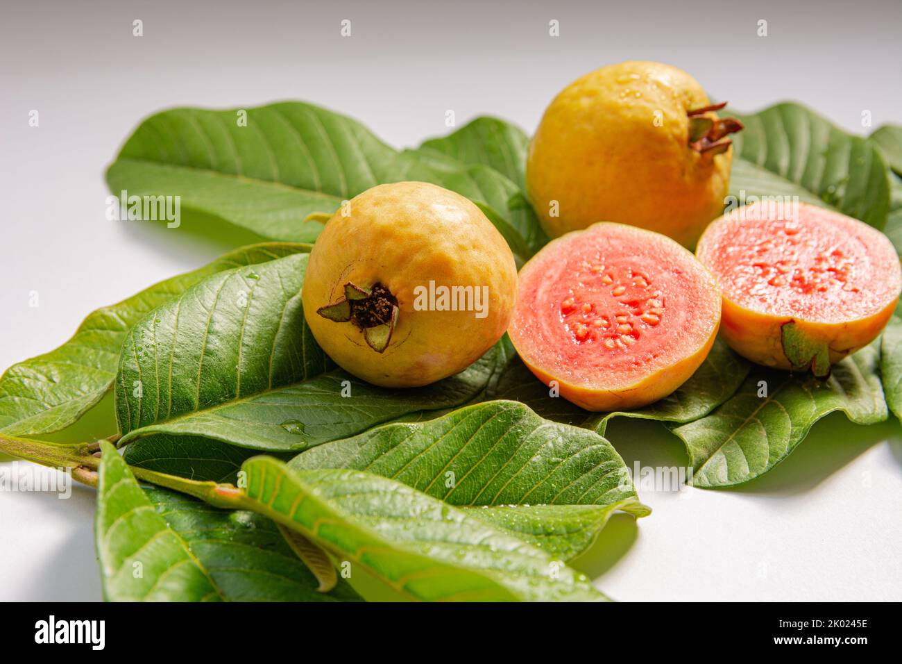 Ripe yellow fruits and leaves of guava on a white background. Beautiful ...