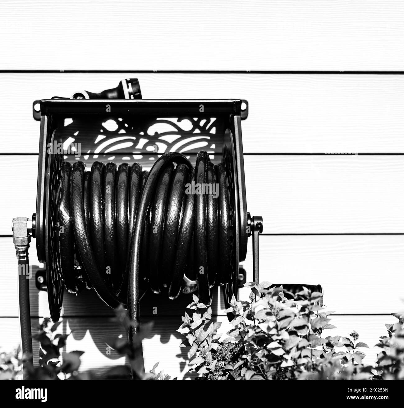 Decorative metal hose storage wheel mounted on the exterior of a ...