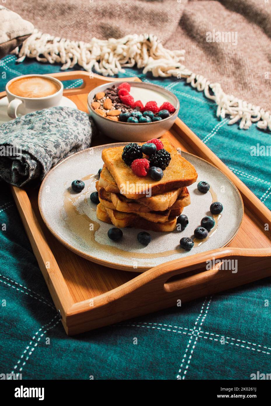 Cozy breakfast in bed, yogurt bowl with berries and nuts, french toasts ...