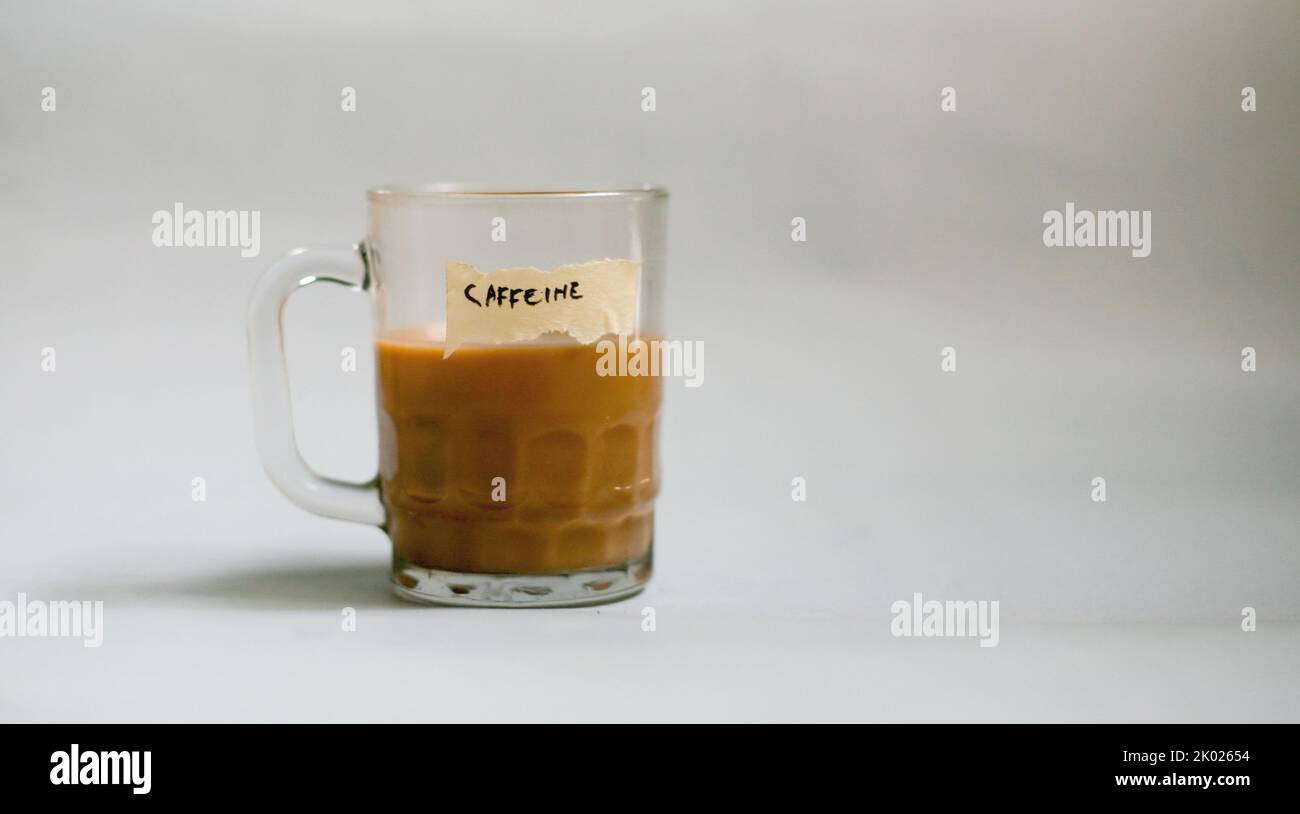 drinking glass of coffee latte with text word caffeine written on duct ...