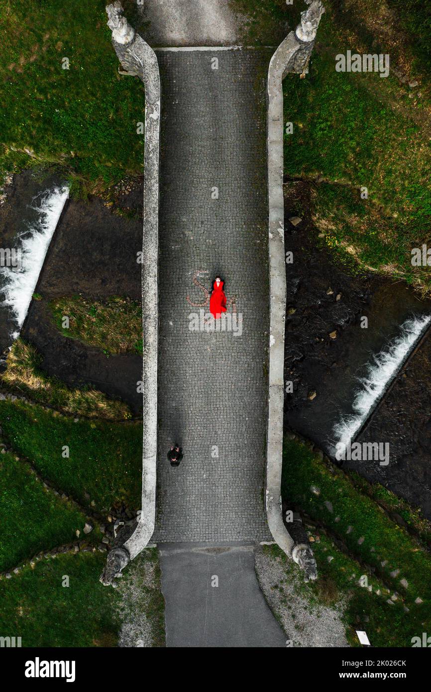 Stone arched bridge in the park, pedestrian bridge over the cascading ...