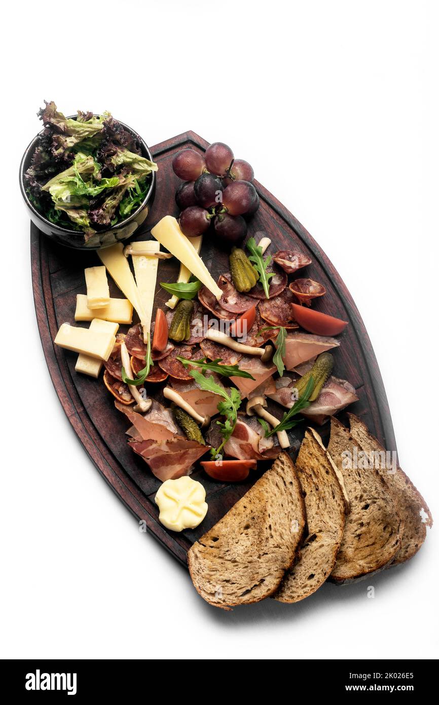 mixed cheese and cold cuts snack platter board on white background ...