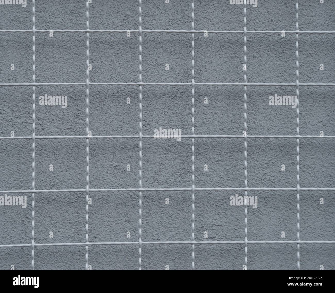 a metal grid and a gray wall behind it Stock Photo - Alamy