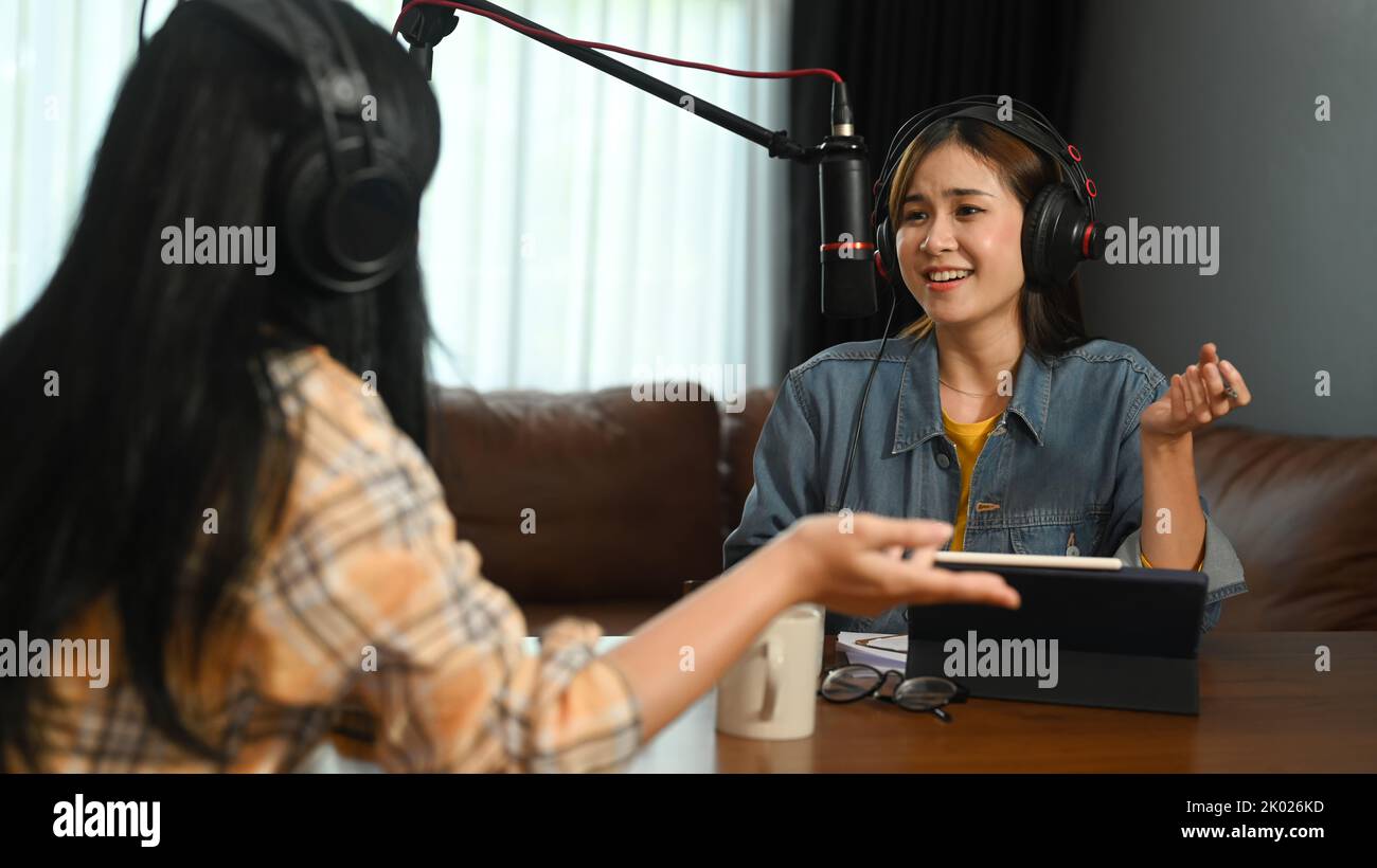 Friendly radio host wearing headphone and recording voice over radio ...