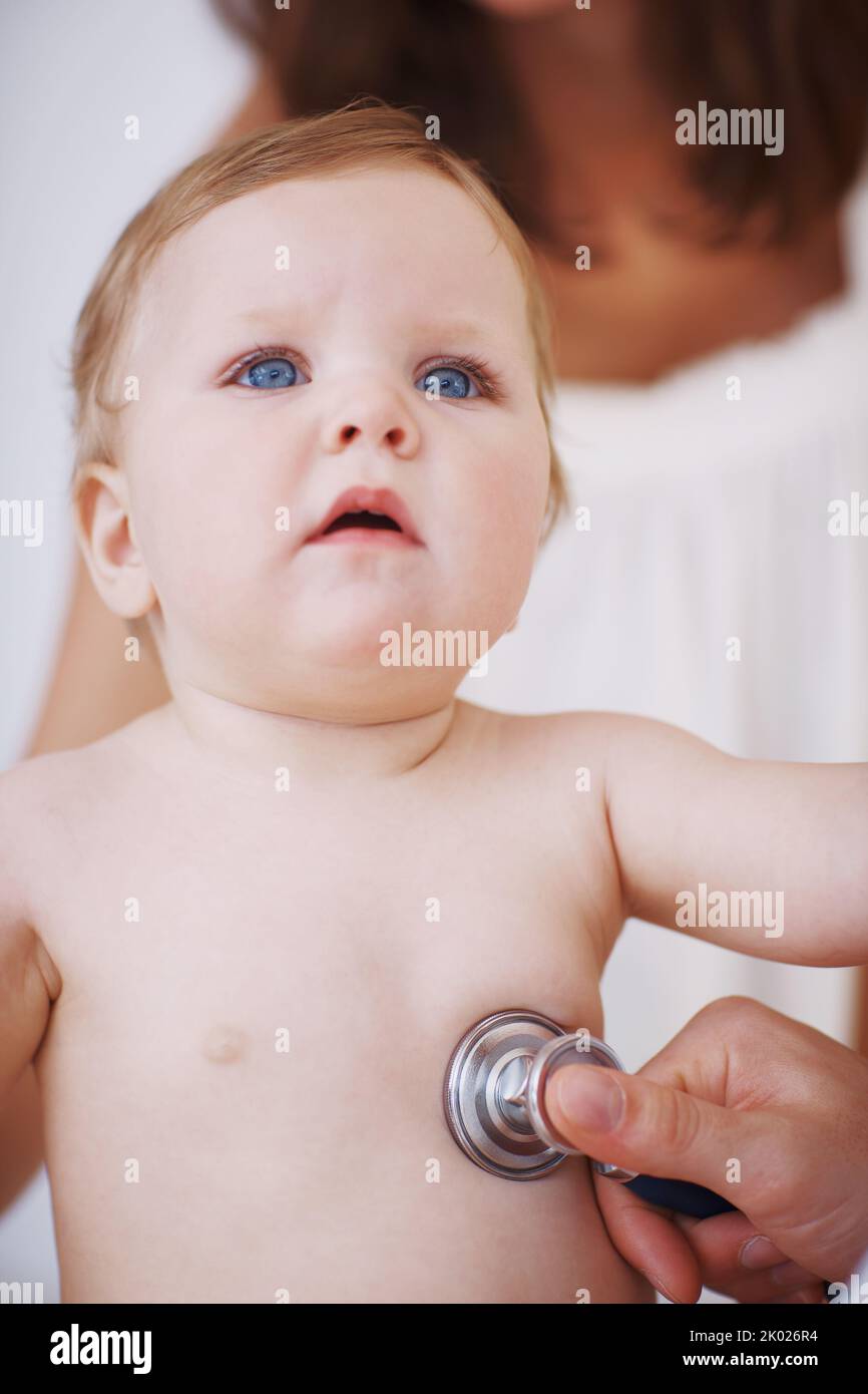Whats up, Doc. A baby girl being examined by a doctor while her mother ...