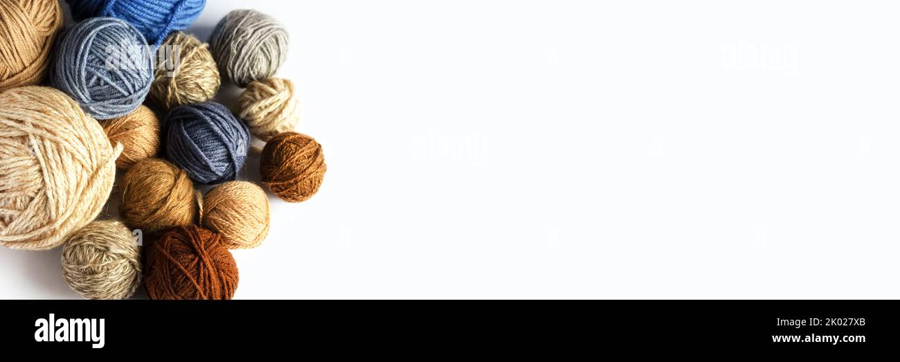 Blue, gray and brown balls of knitting thread on a light background for ...