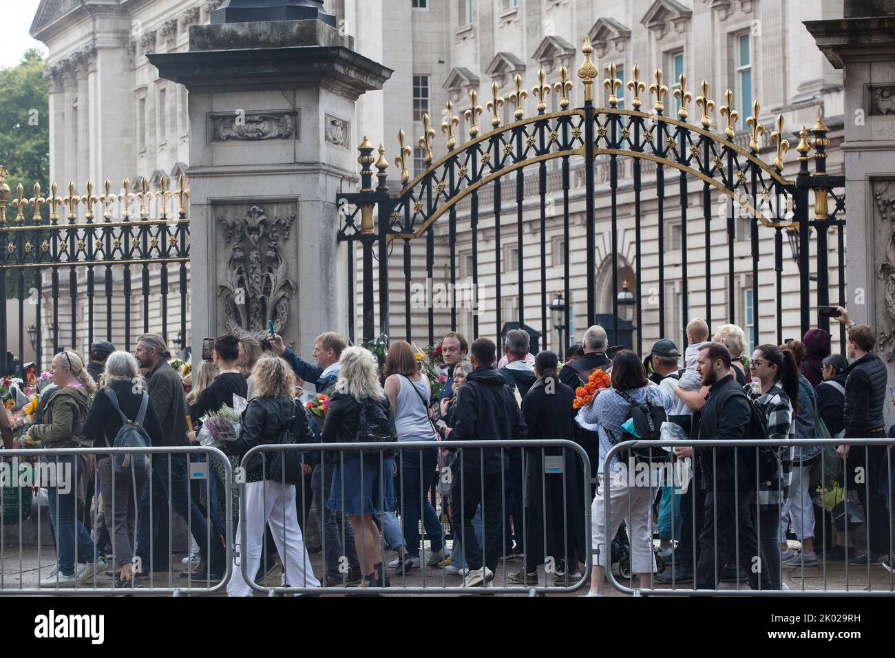 Crowds gather at Buckingham Palace to lay flowers, take photos and mark ...