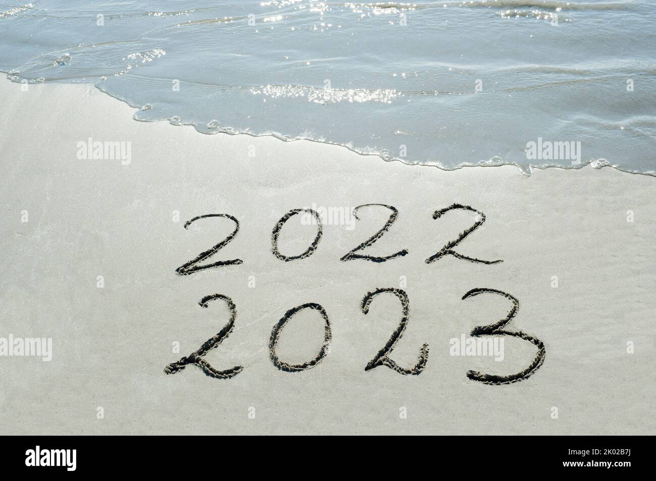 Concept or conceptual 2022 2023 handwritten text in sand on a beach ...
