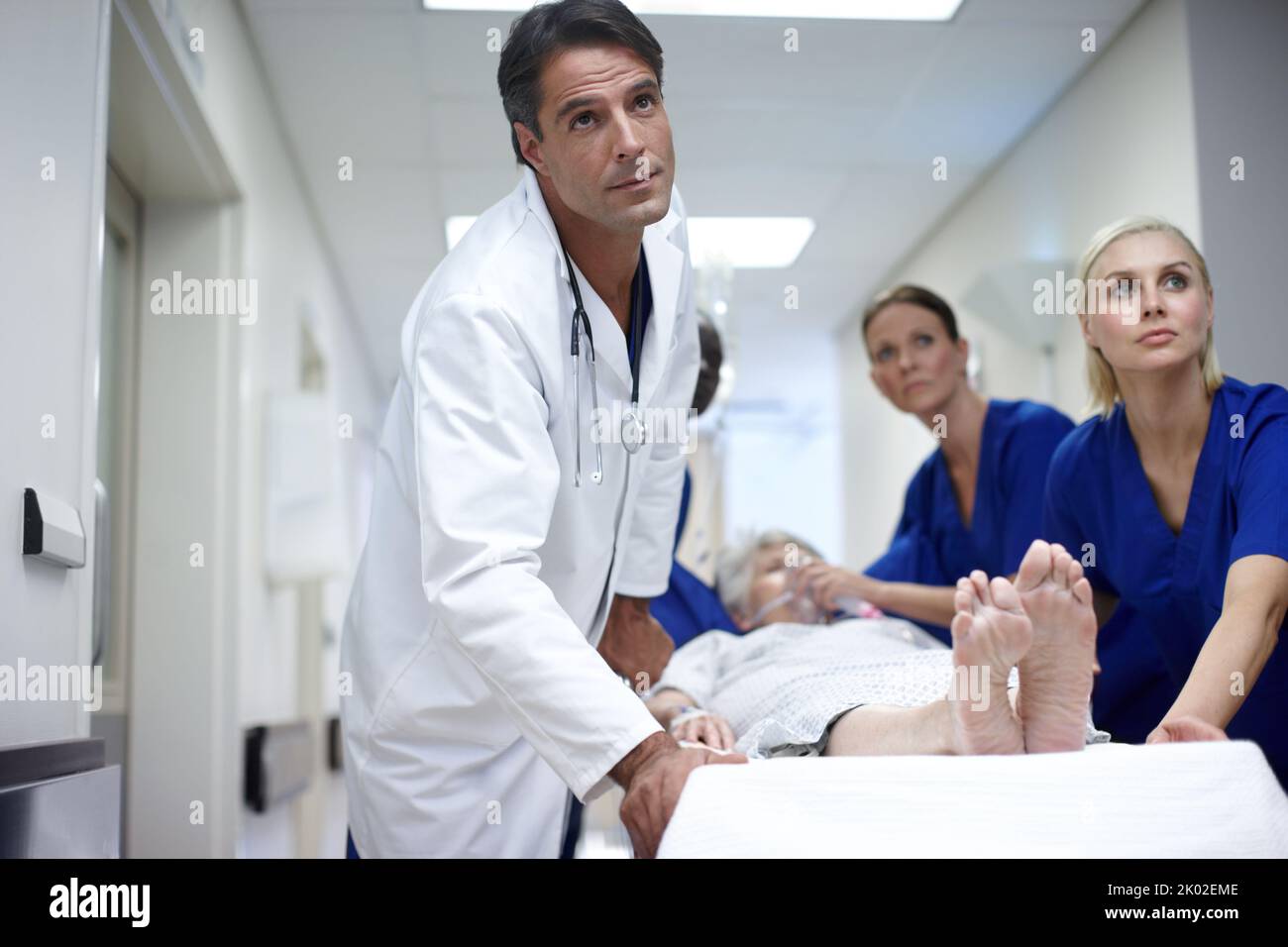 Moving her to the recovery theatre. A team of doctors pushing a patient ...