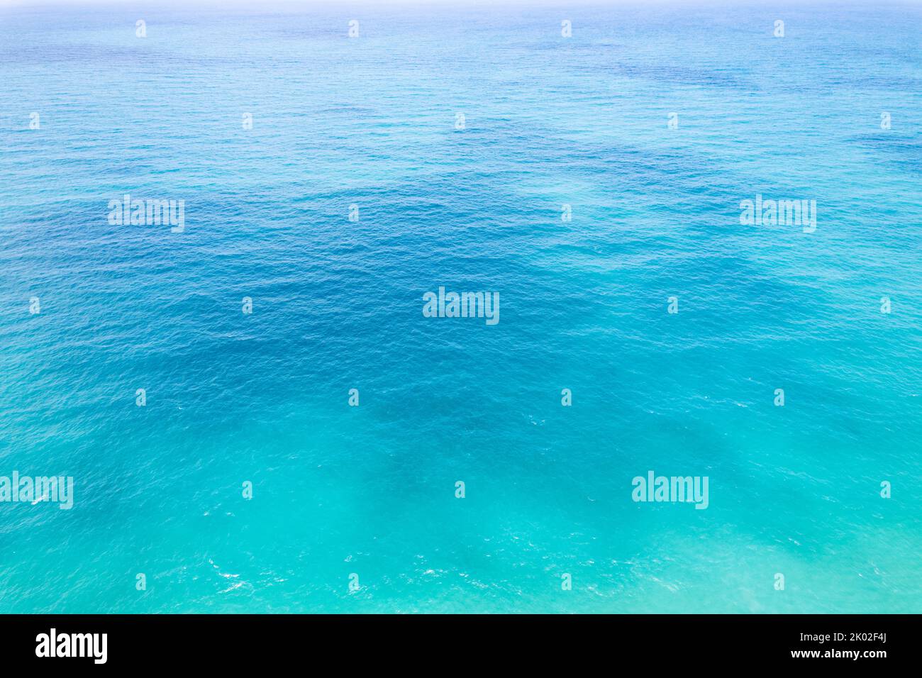 Aerial view of a blue sea water background and sun reflections. Aerial ...