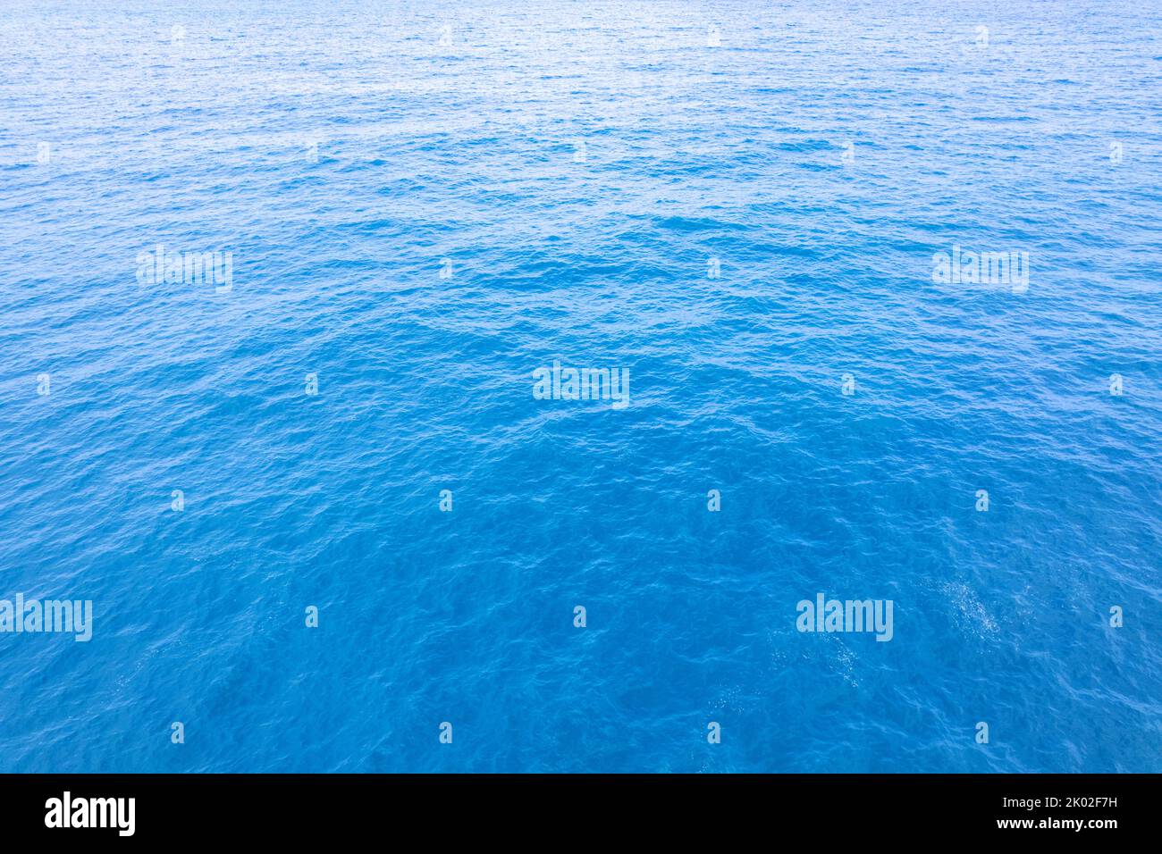 Aerial view of a blue sea water background and sun reflections. Aerial ...