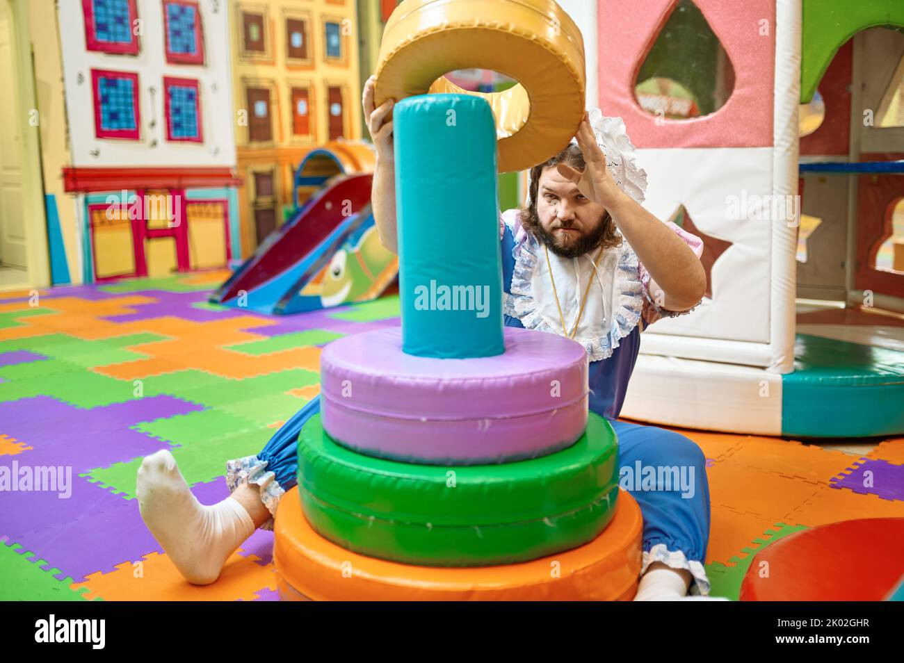 Cute funny man wearing like baby playing with soft pyramid Stock Photo ...