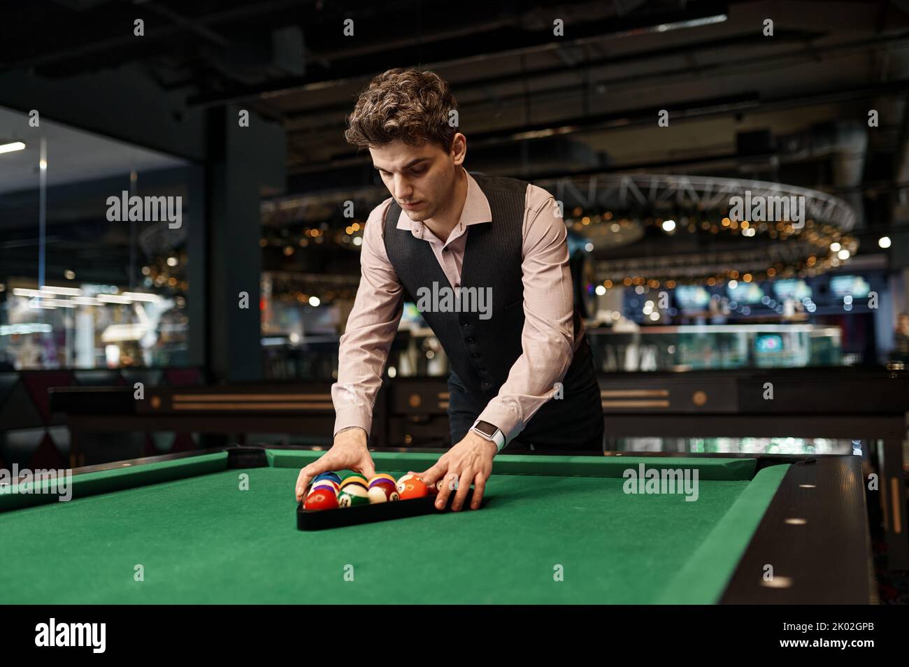 Man putting billiard balls in triangle rack Stock Photo - Alamy