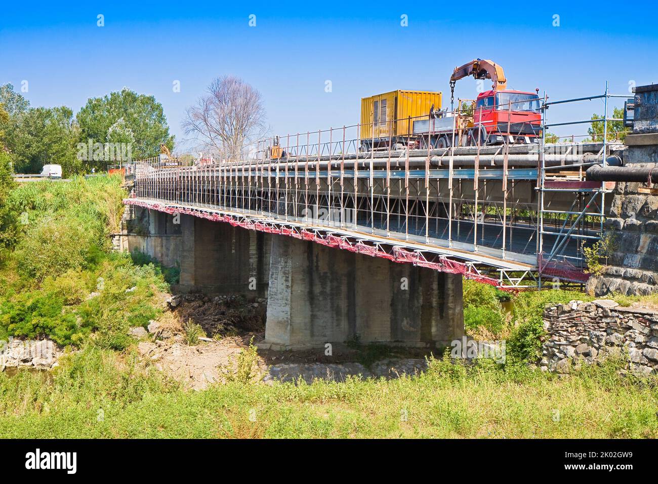 Restoration of an old damaged concrete bridge crossing a river with ...