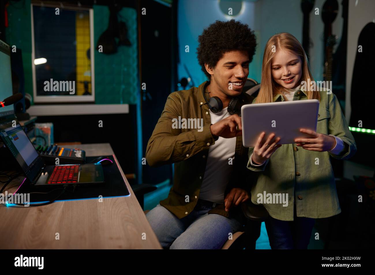 Audio engineer with young singer working in music recording studio ...