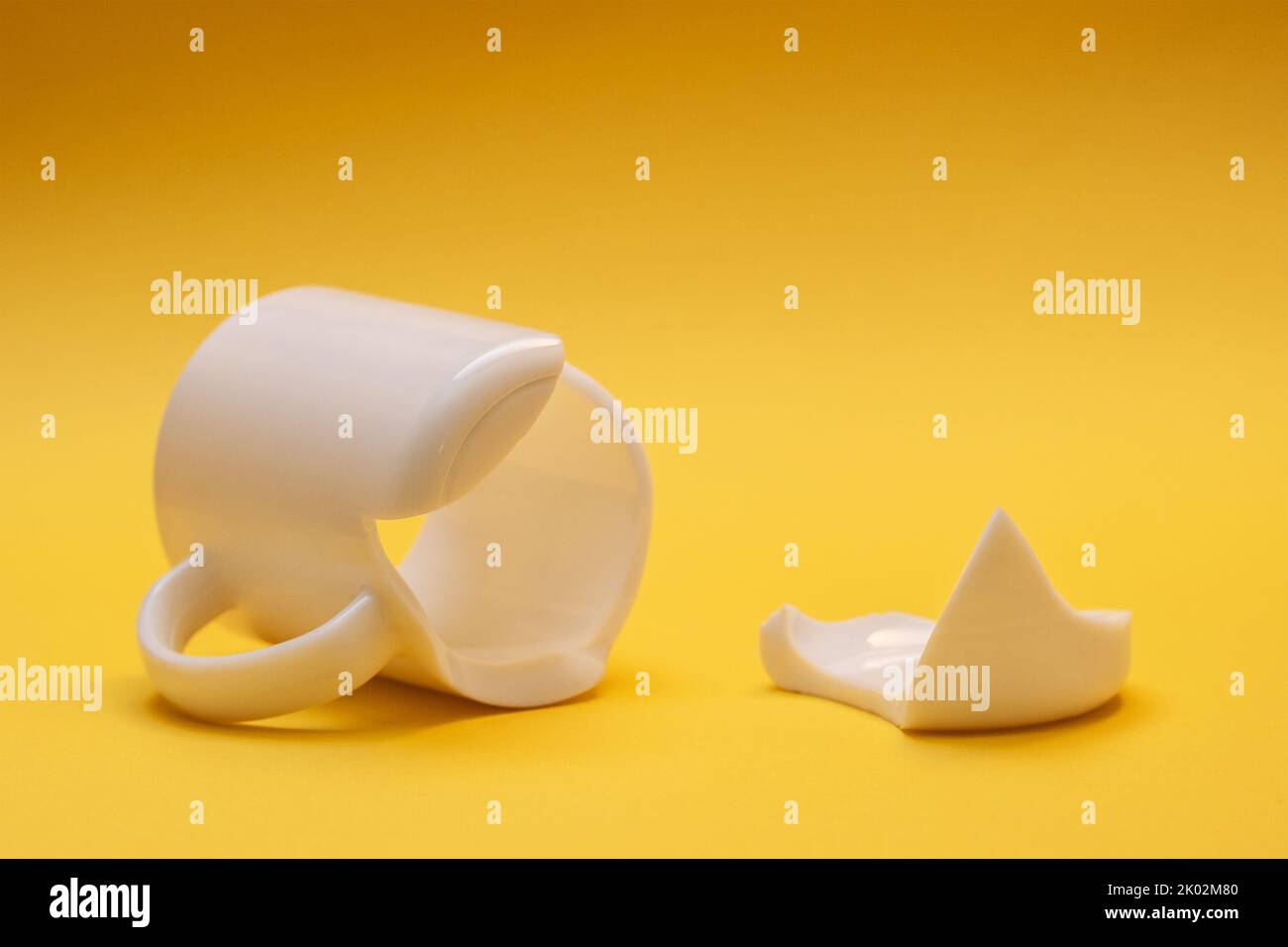 Splinters of the broken tea mug on a yellow background Stock Photo - Alamy