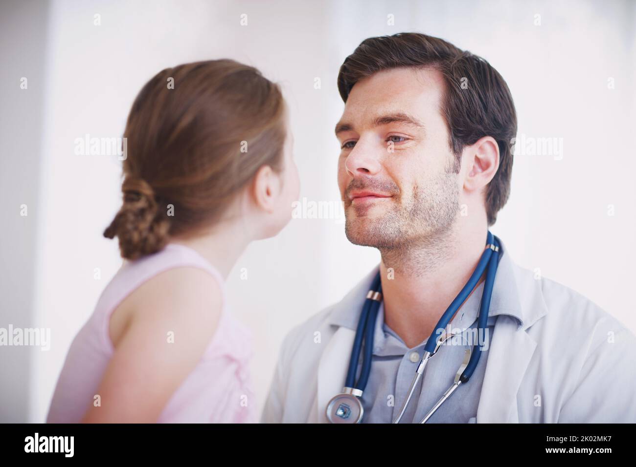 Giving her a little reassurance. A male doctor examining a little girl ...