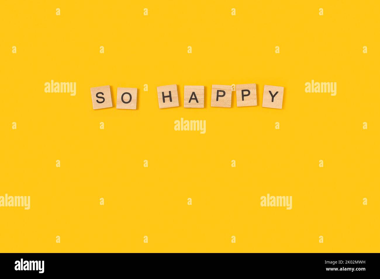 So happy write with wooden letter blocks on a yellow background Stock ...