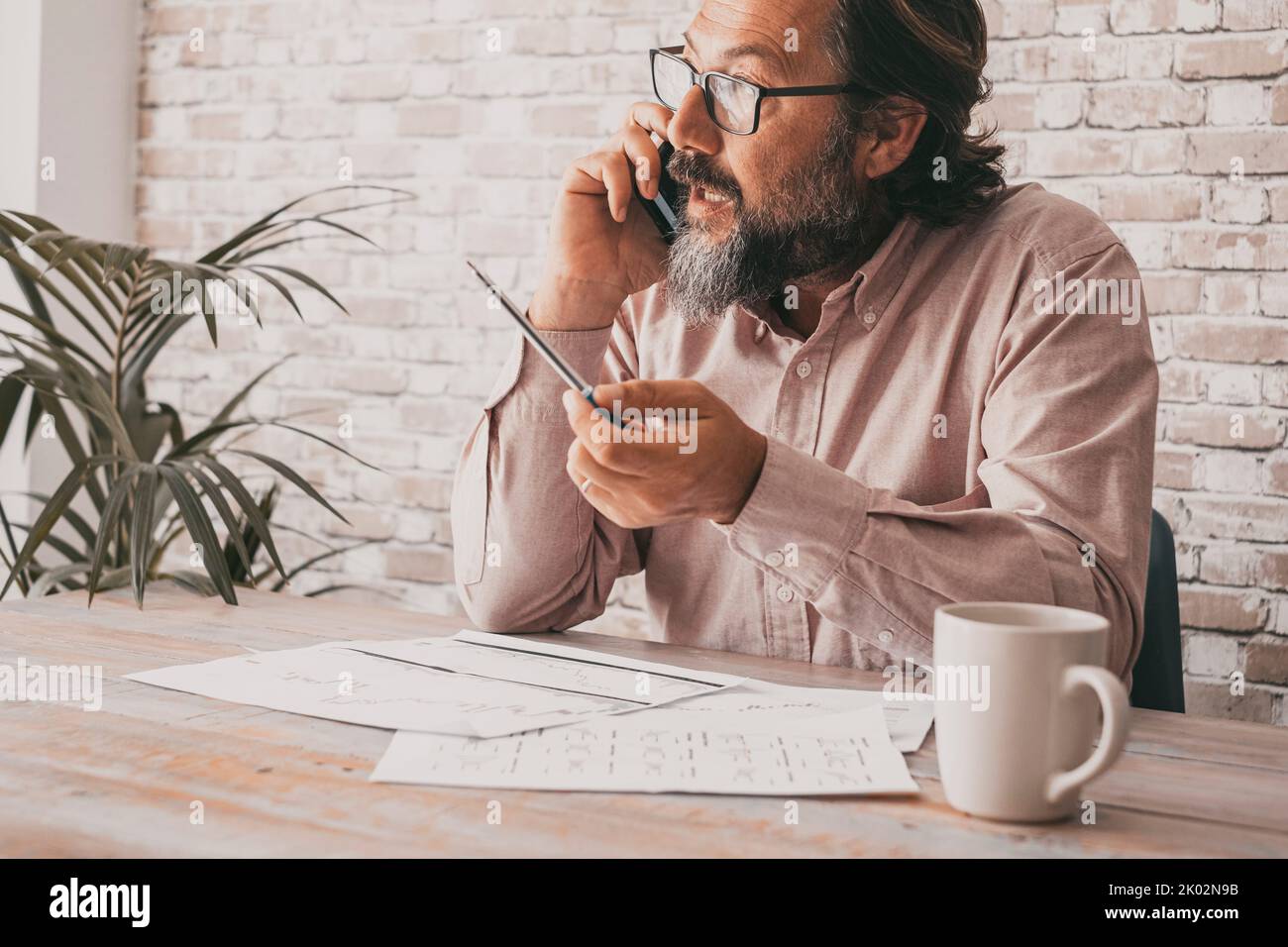 Professional worker speaking at the phone sitting at the desk. Business ...