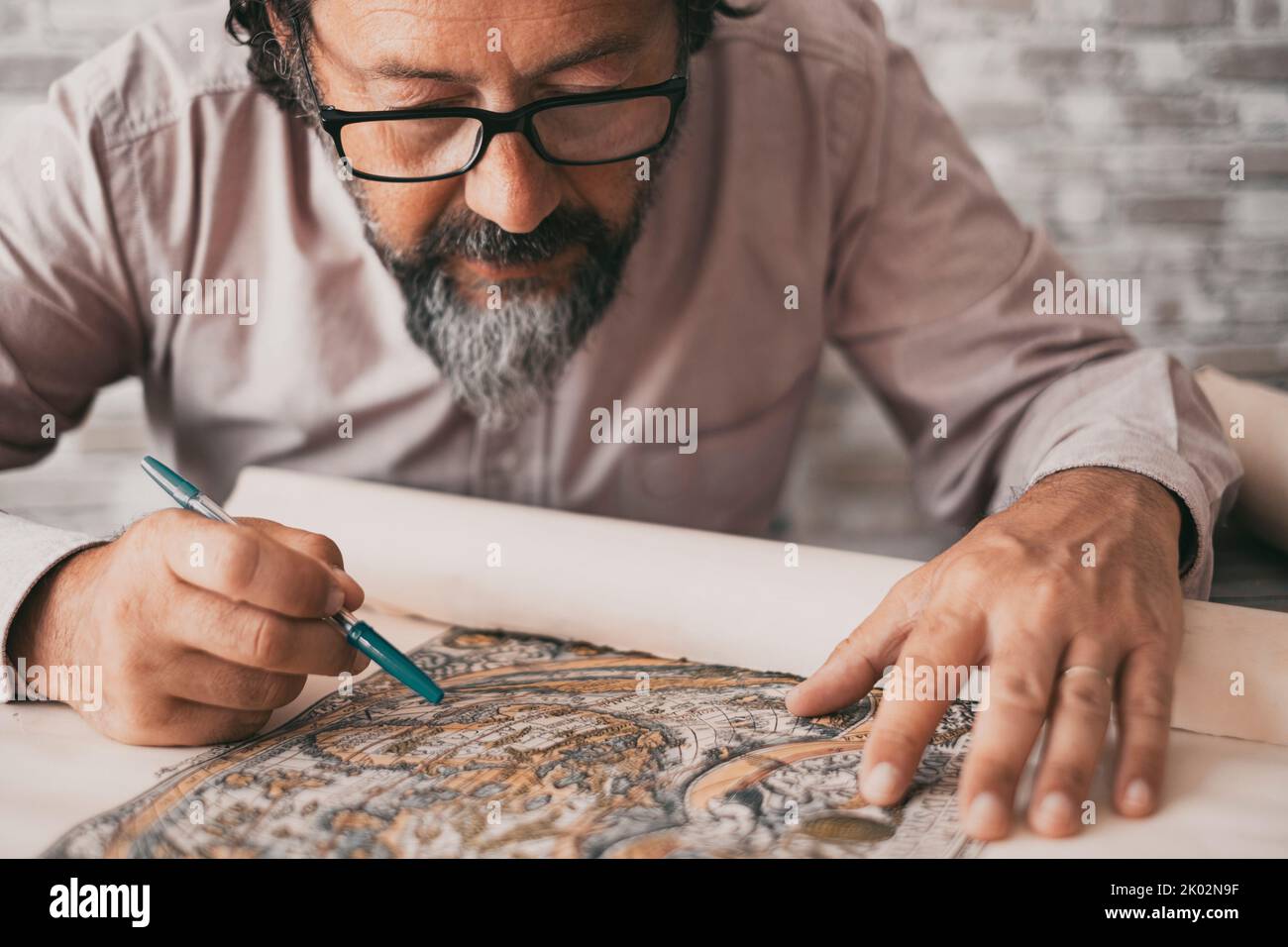 Close up portrait of man busy studying a paper design map on the desk ...