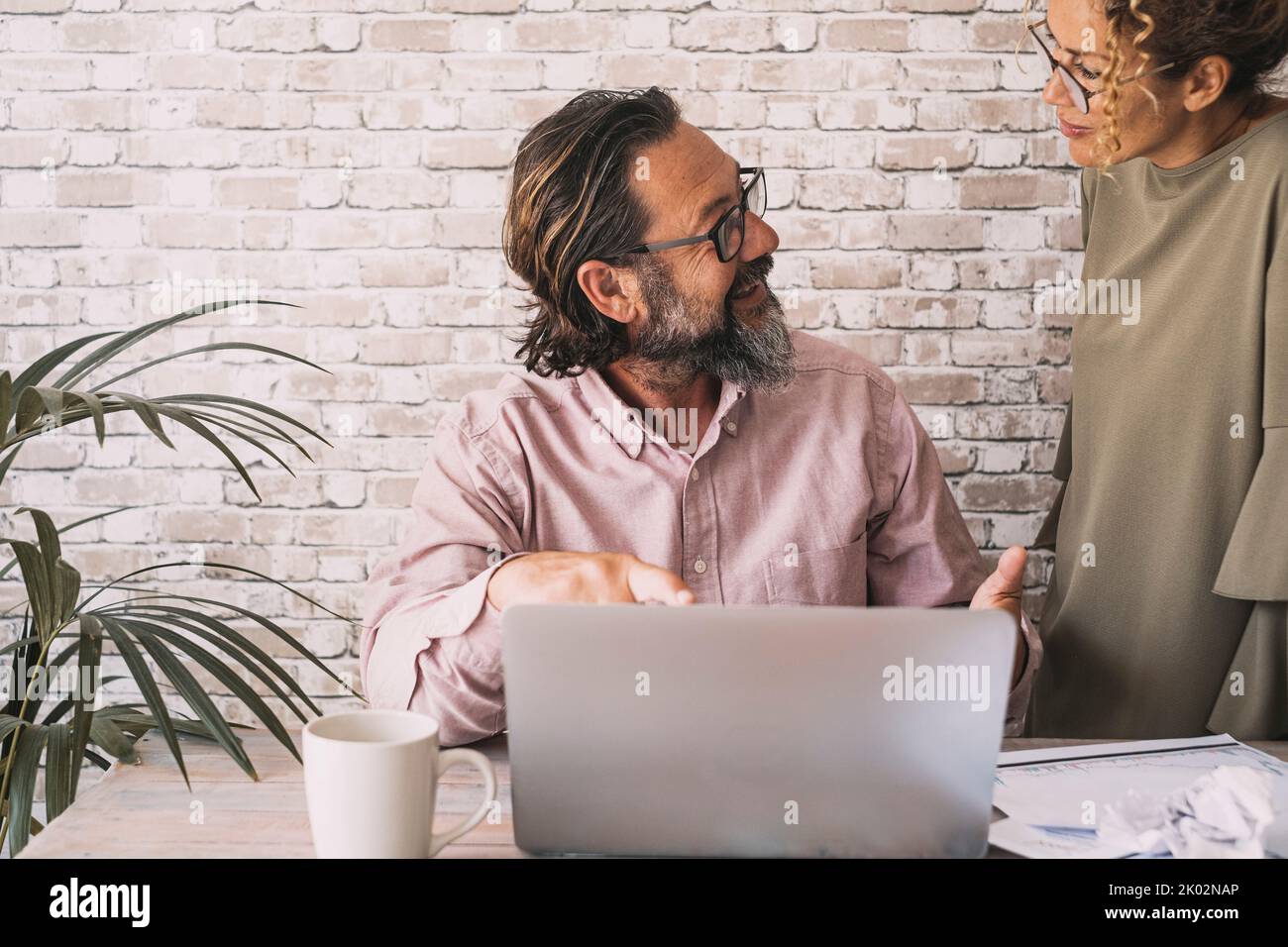 Man and woman enjoy working together. Modern people using laptop at ...