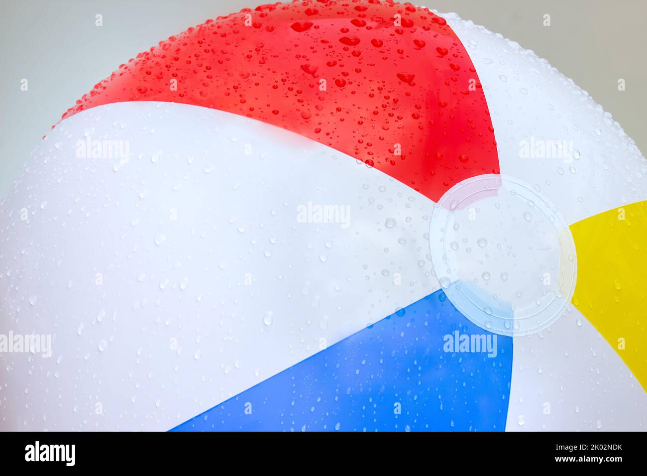 Drops of water on a beach ball with red, yellow, blue and white, beach ...