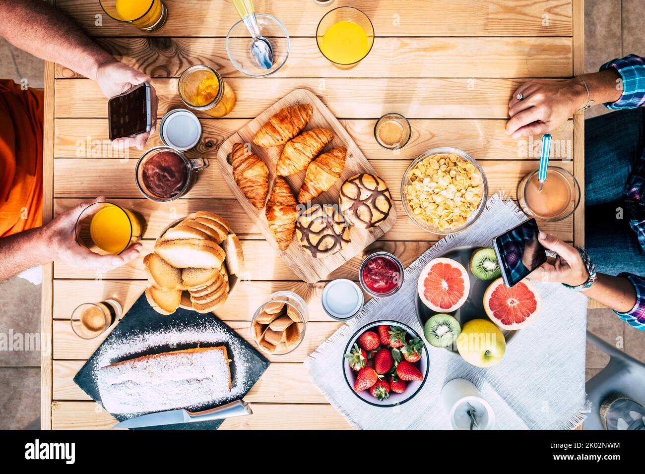 Vertical view of table full of breakfast food and group of people ...