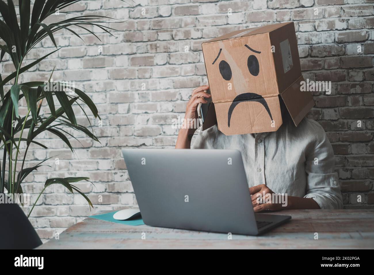 People at work with sad carton box on head diong phone call in front of ...