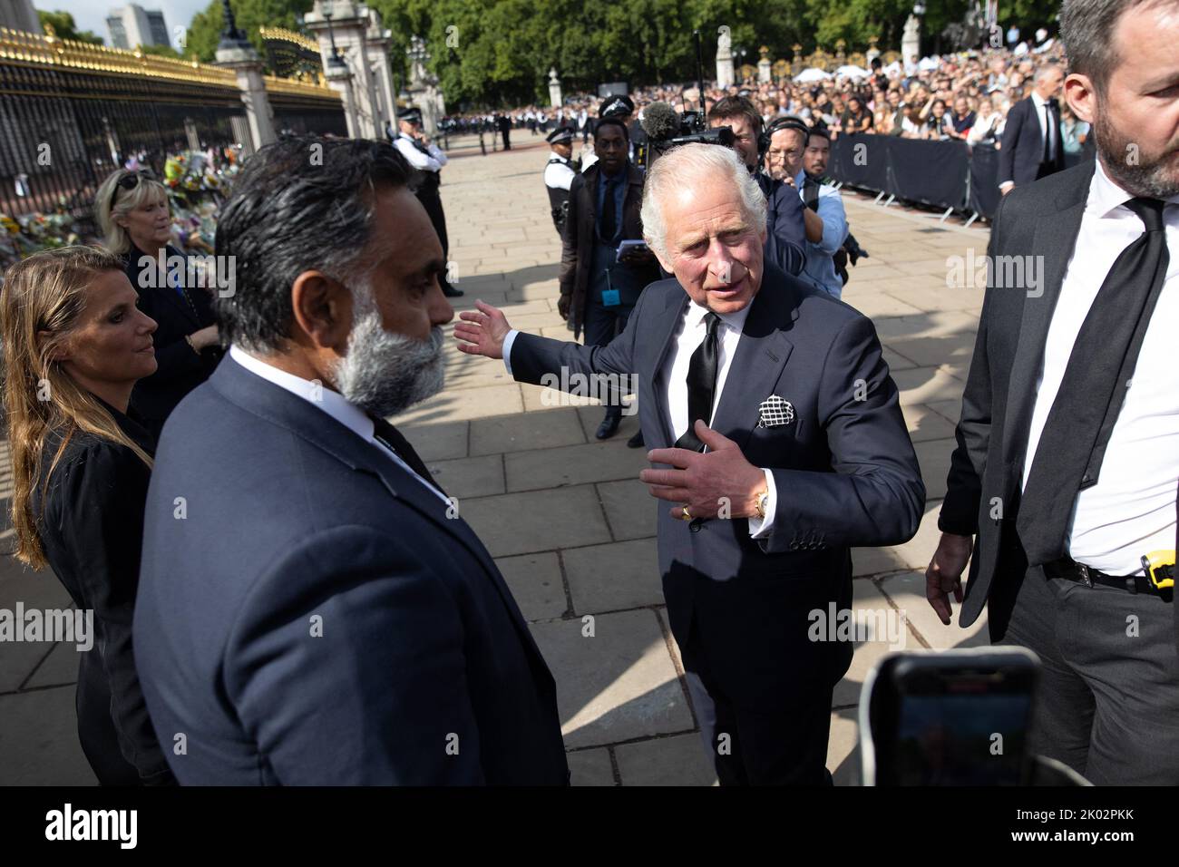 King Charles is cheered by the crowd as they walk into Buckingham ...
