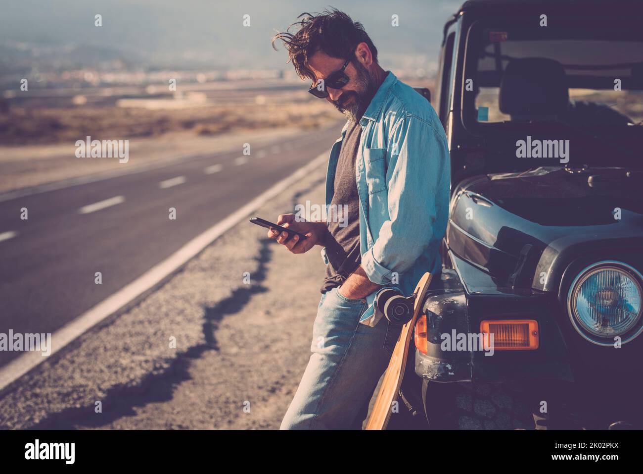 Traveler man use phone mobile cnnection standing against a black off ...