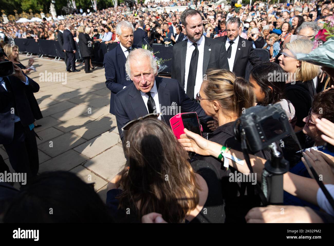 King Charles is cheered by the crowd as they walk into Buckingham ...