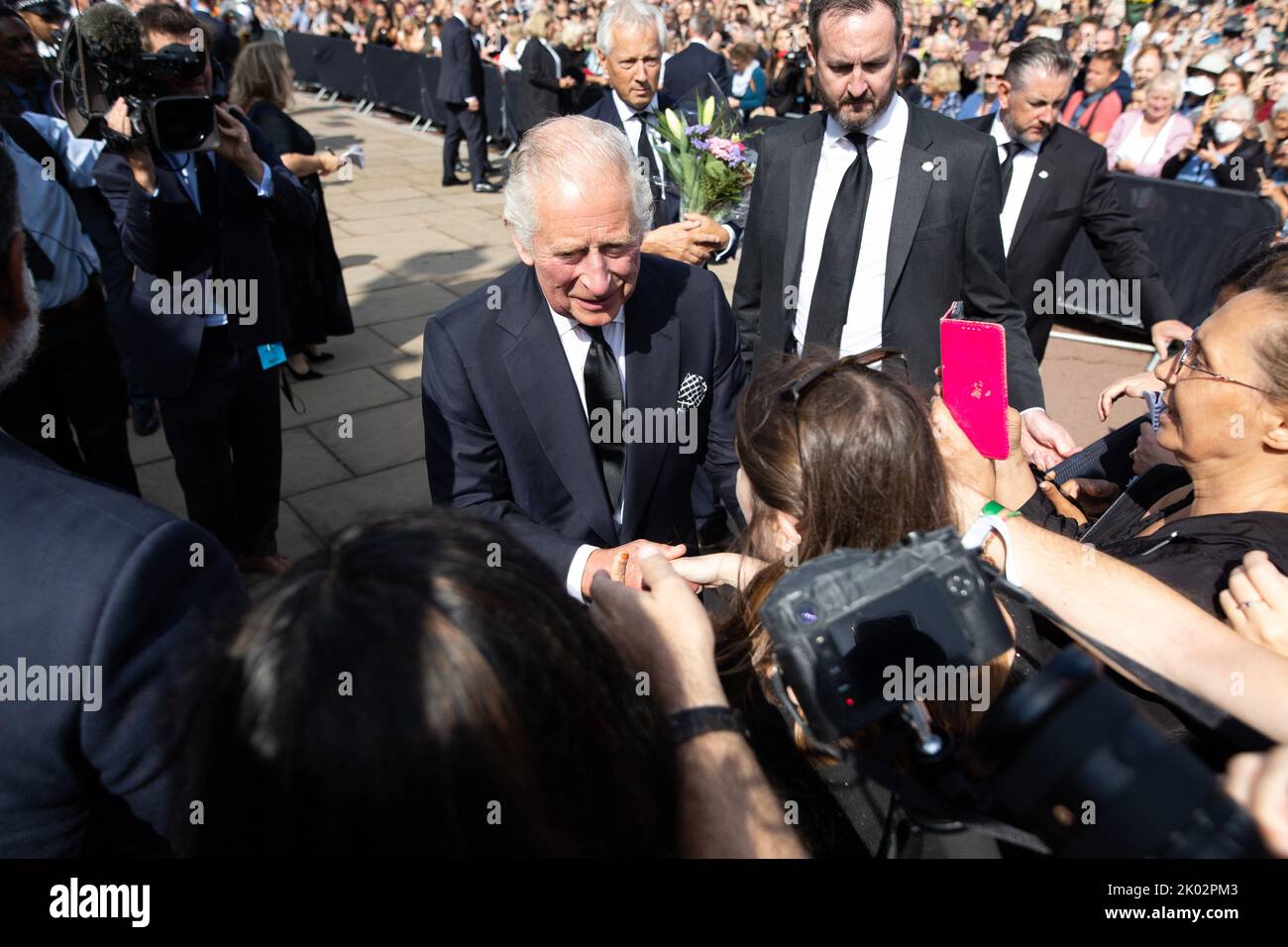 King Charles is cheered by the crowd as they walk into Buckingham ...