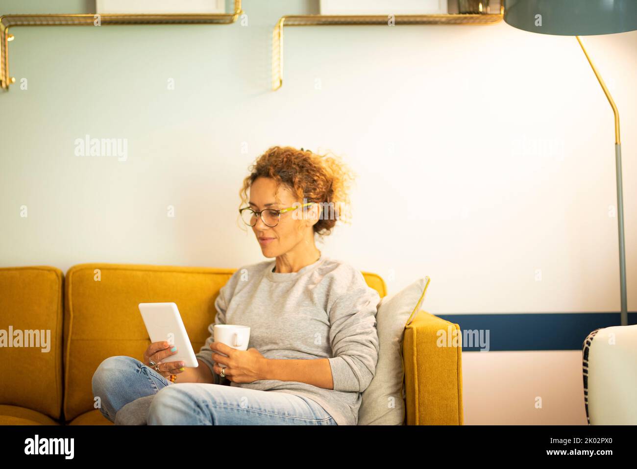 Adult woman have relax leisure activity at home sitting onthe sofa and ...