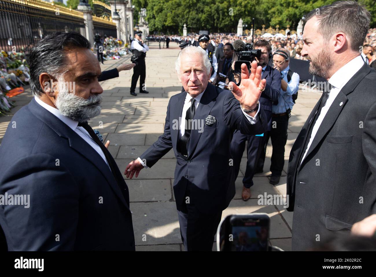 King Charles is cheered by the crowd as they walk into Buckingham ...