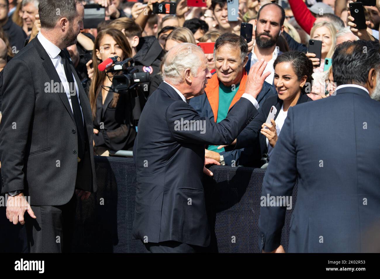 King Charles is cheered by the crowd as they walk into Buckingham ...