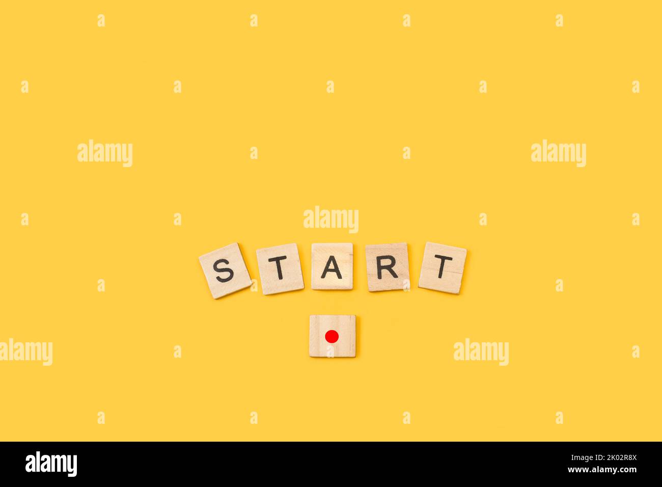 Start word write with wooden letter cubes and a block as a red button ...