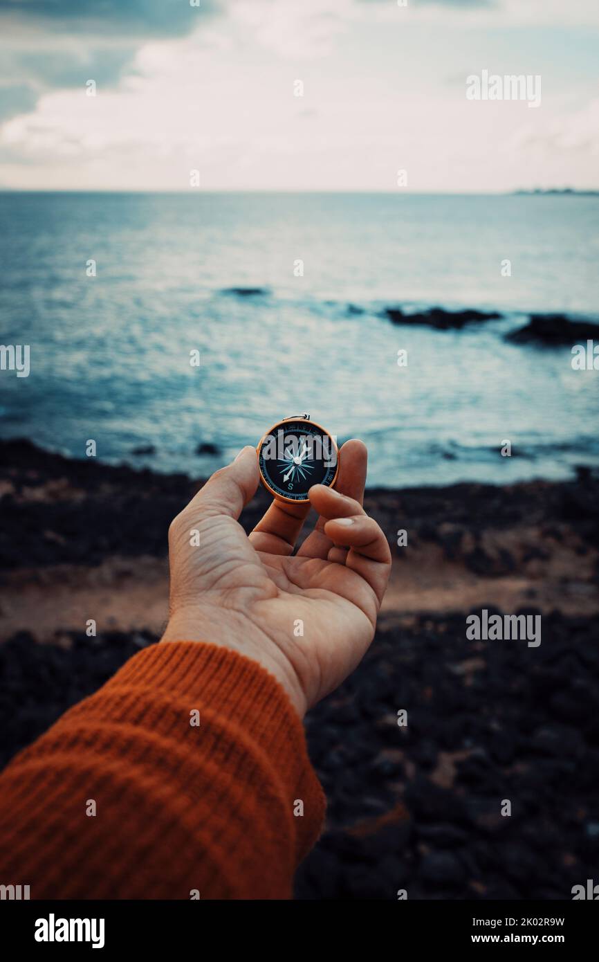 Pov of man hand holding navigational travel compass to find direction ...