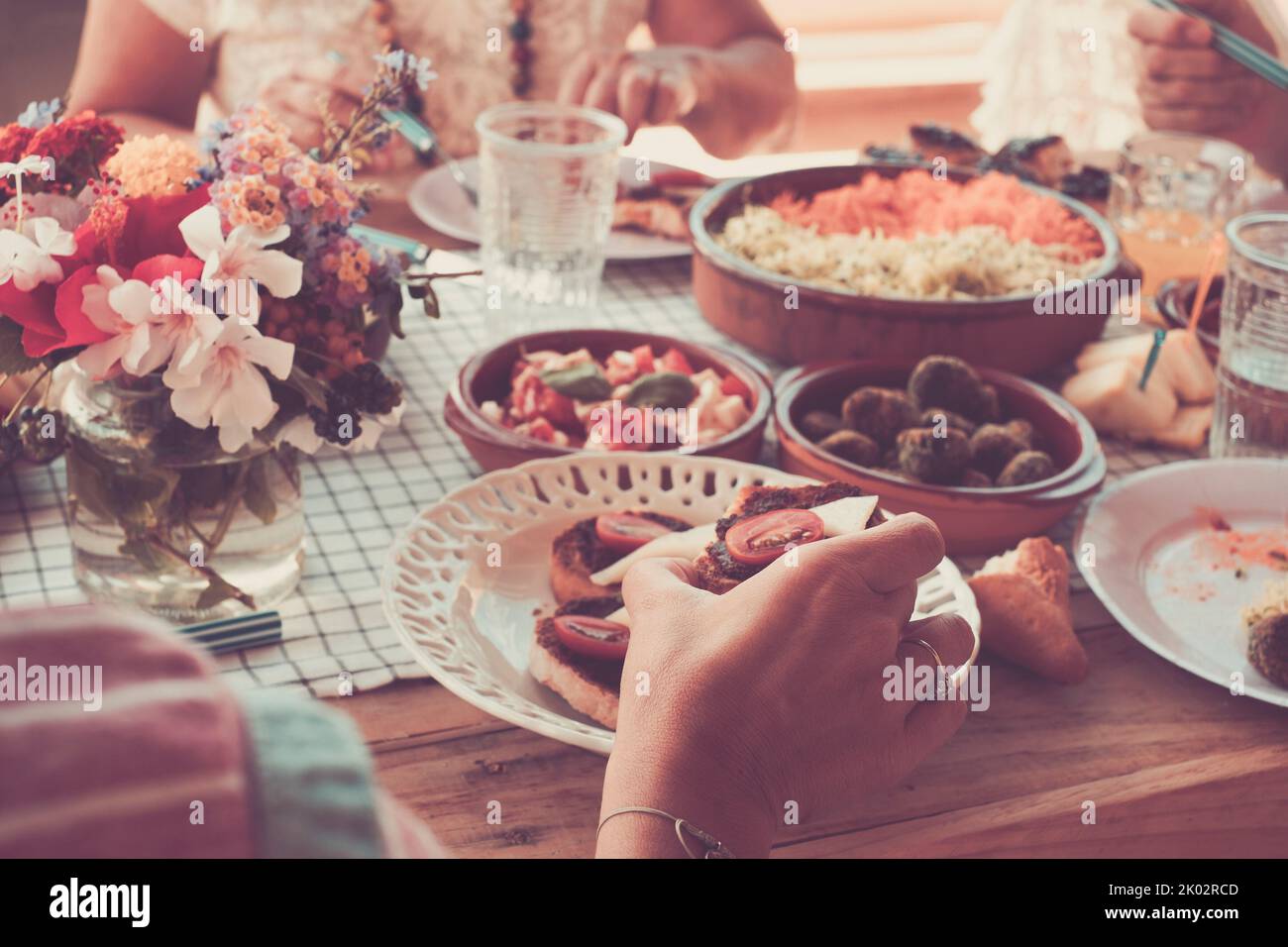 Close up in pink color mood filter of people taking food from the table ...