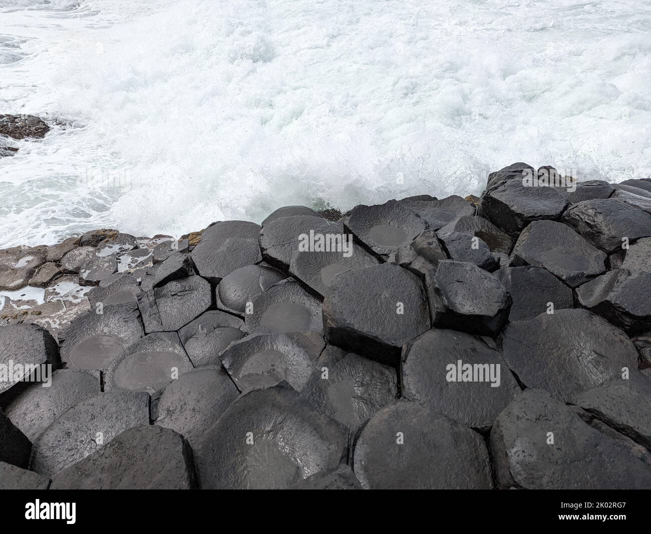 A surface of the top of basalt columns with waves Stock Photo - Alamy