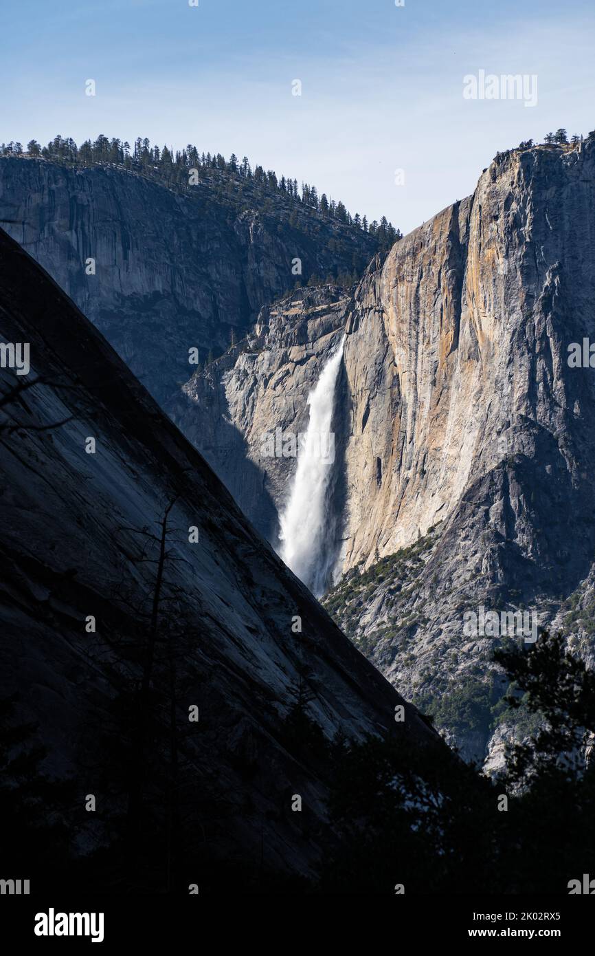 The vertical view of Yosemite falls under the blue sky on a sunny day ...