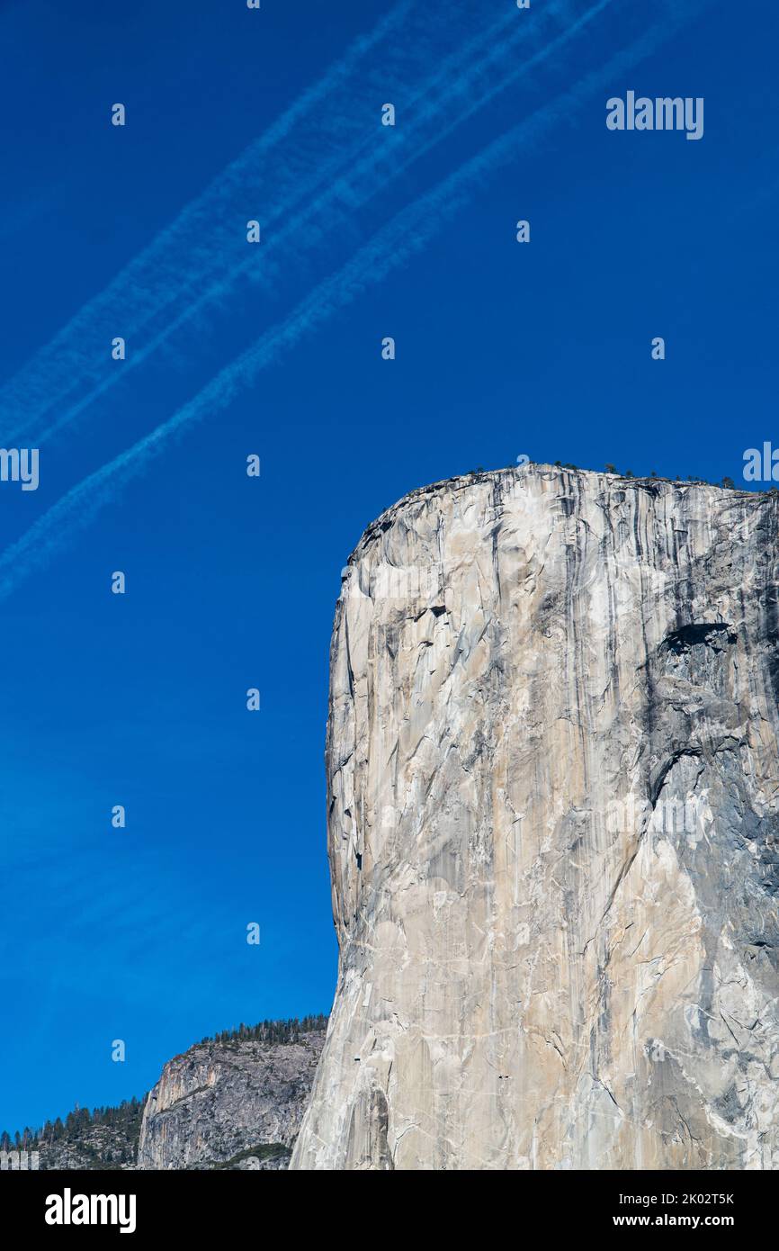 The vertical low-angle view of a rocky cliff under the blue sky Stock ...